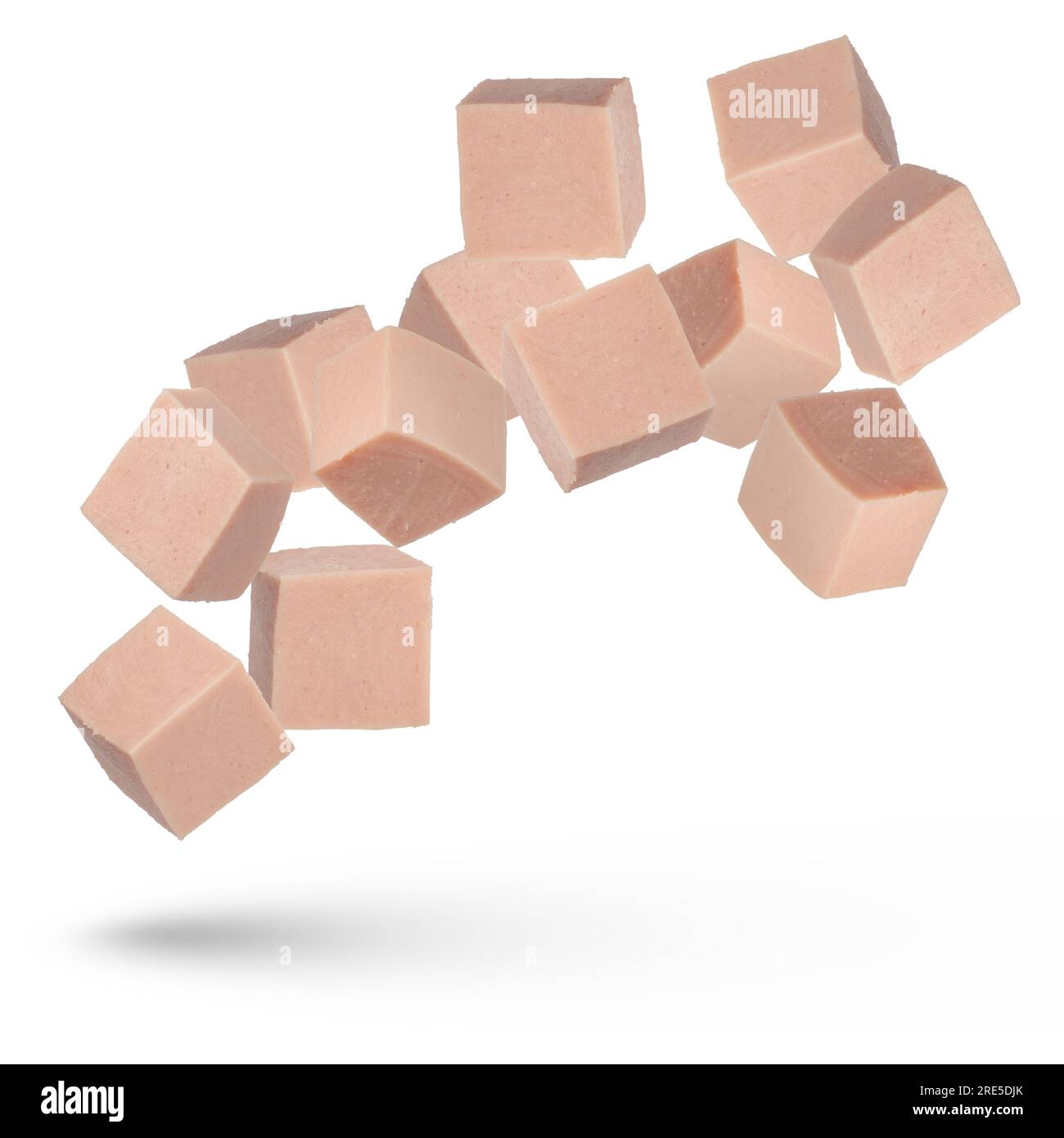 Flying sausage. Cubes of boiled turkey sausage on a white isolated ...