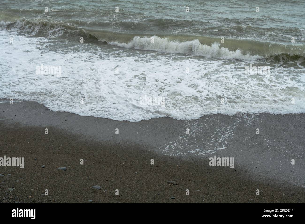 Sea shore with pebbles, wet sea pebbles on the beach and quiet sea surf ...