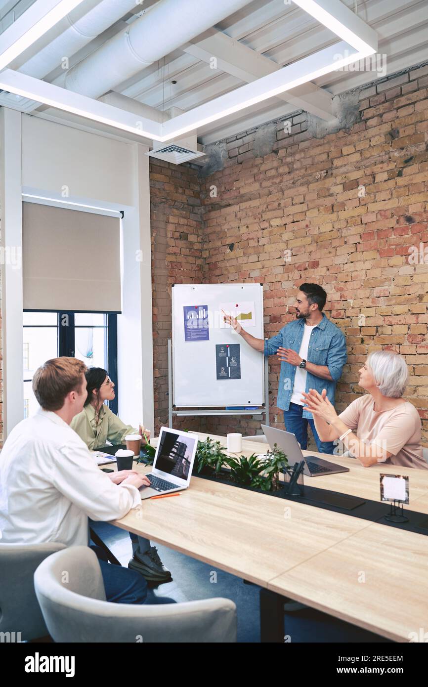 A male manager talking with his colleagues in the meeting room while ...