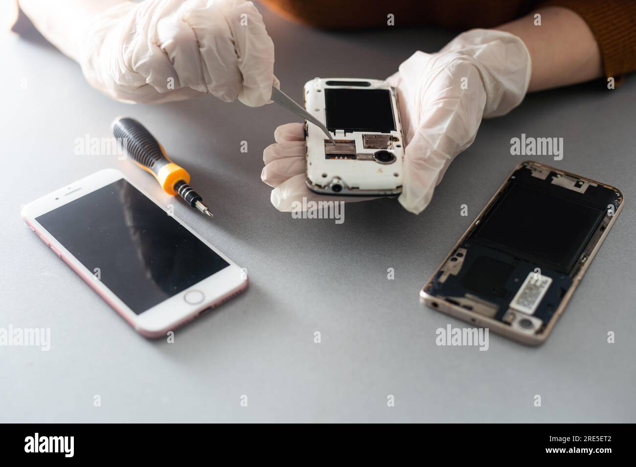 The technician repairing the smartphone's motherboard in the lab with ...