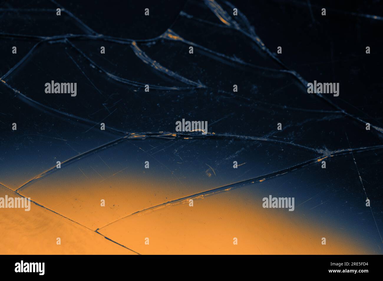 Broken glass background in duotone yellow, orange and blue. Brake ...