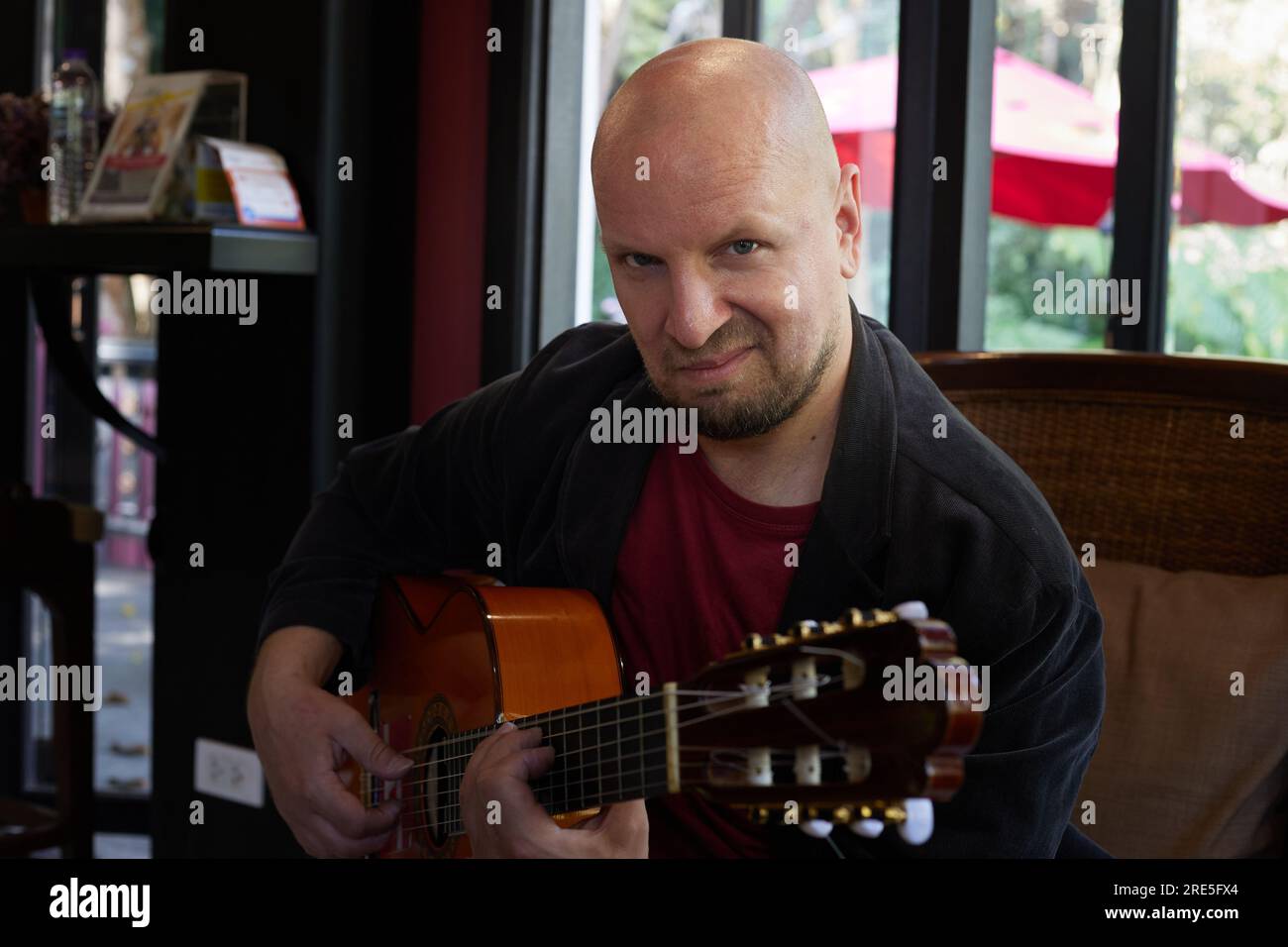 Entertaining male performer plays acoustic guitar with skill and ...