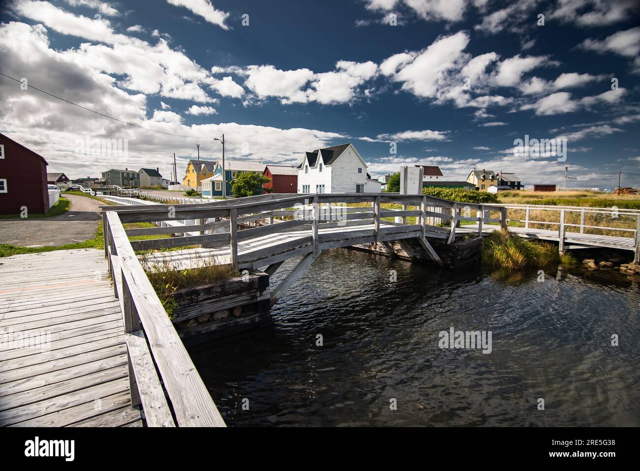 Wooden boardwalk and bridge over a canal with distant East coast beach ...