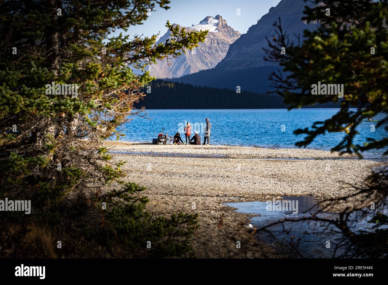 Family having a beachfront dinner overlooking a blue glacier fed lake ...