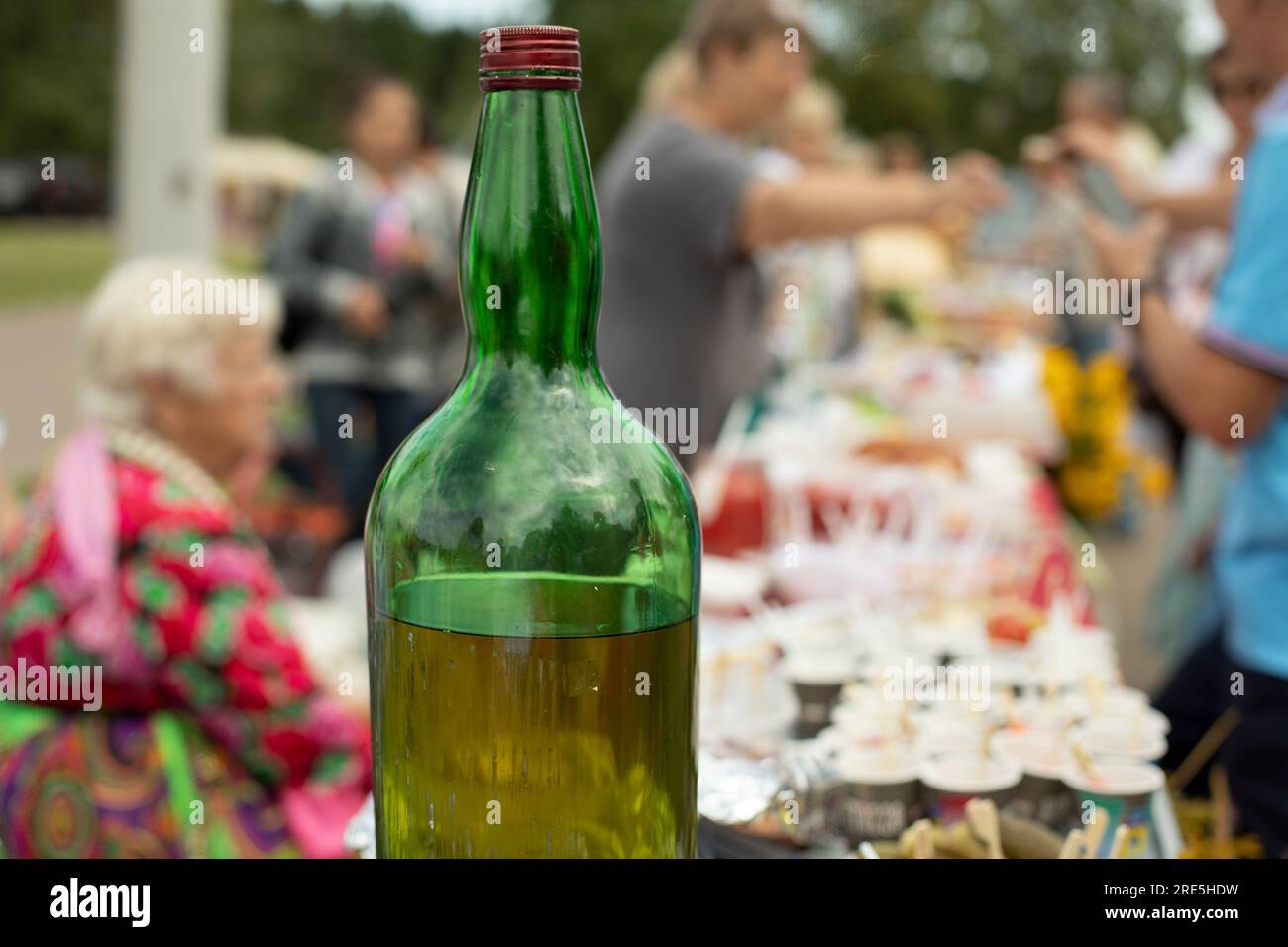 Large bottle of alcohol. Strong drink in green bottle. Festival on ...