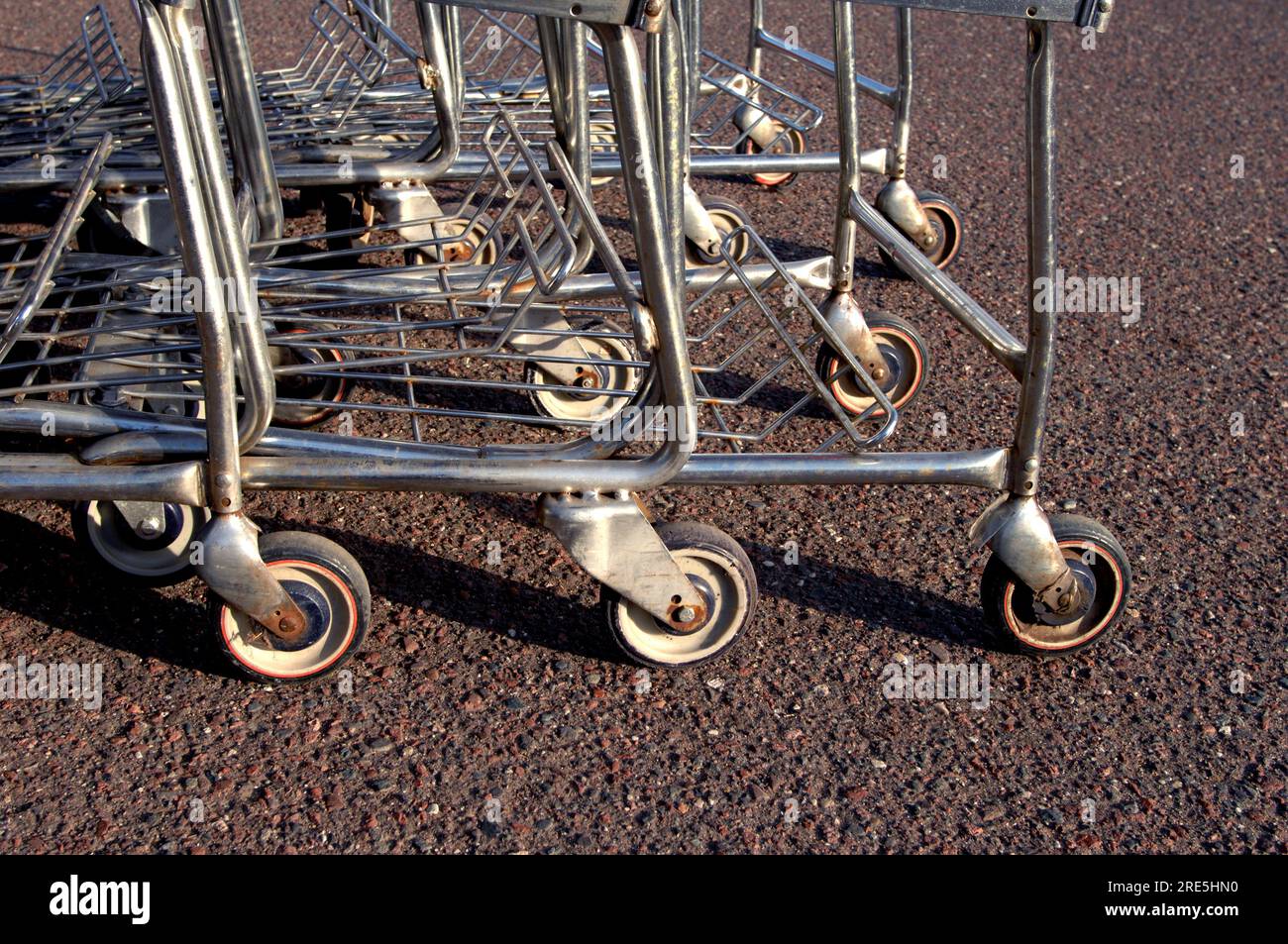 Stack of grocery cars sit on rough pavement of grocery story parking ...