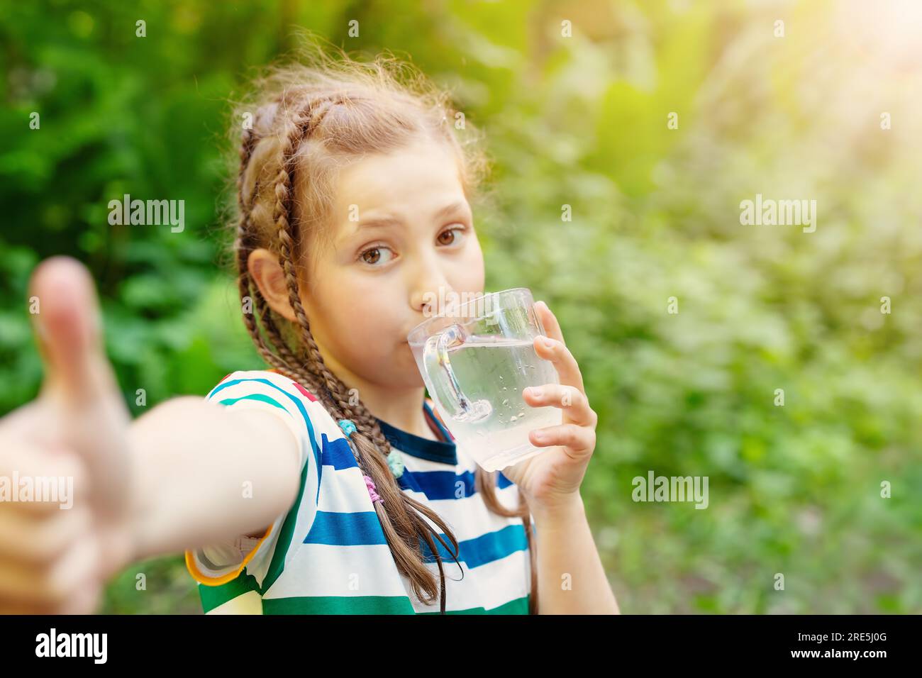 Girl with glass of pure water gestured like outdoors Stock Photo - Alamy