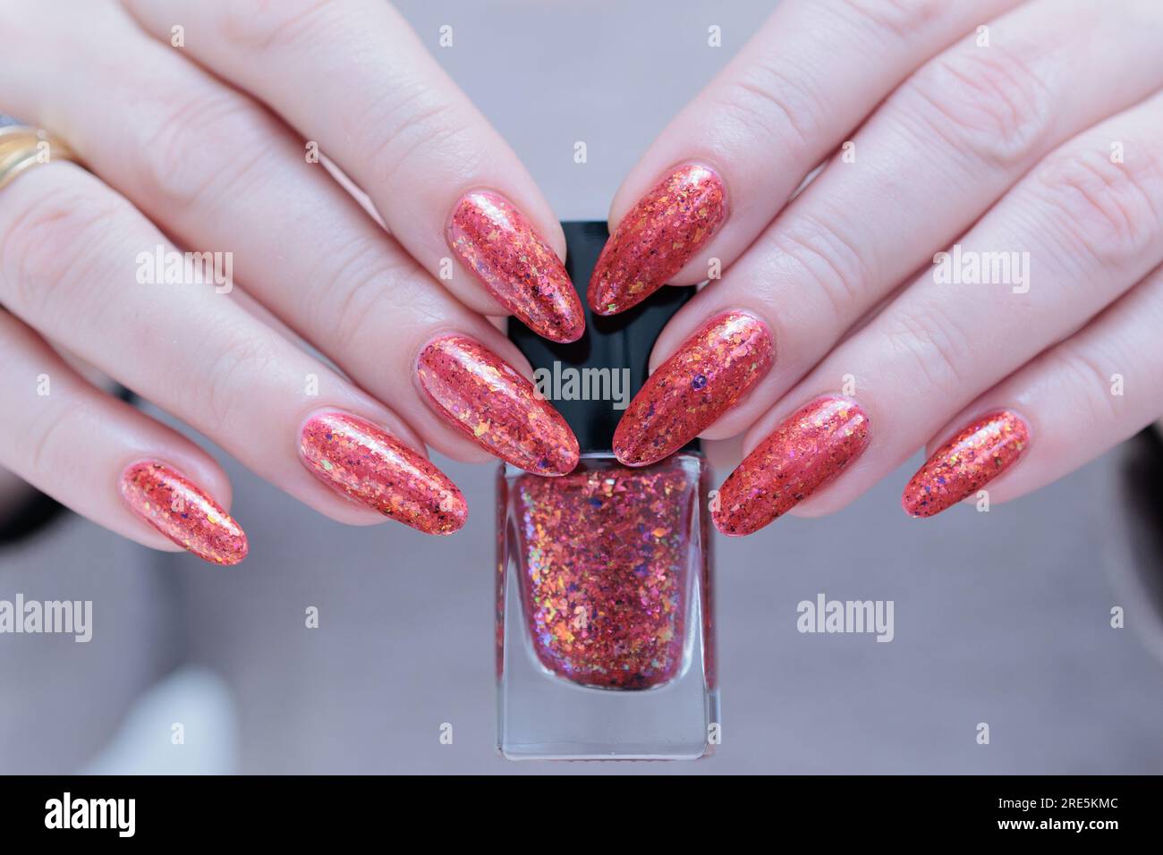 Female beautiful hand with long nails and a bright orange red nail ...