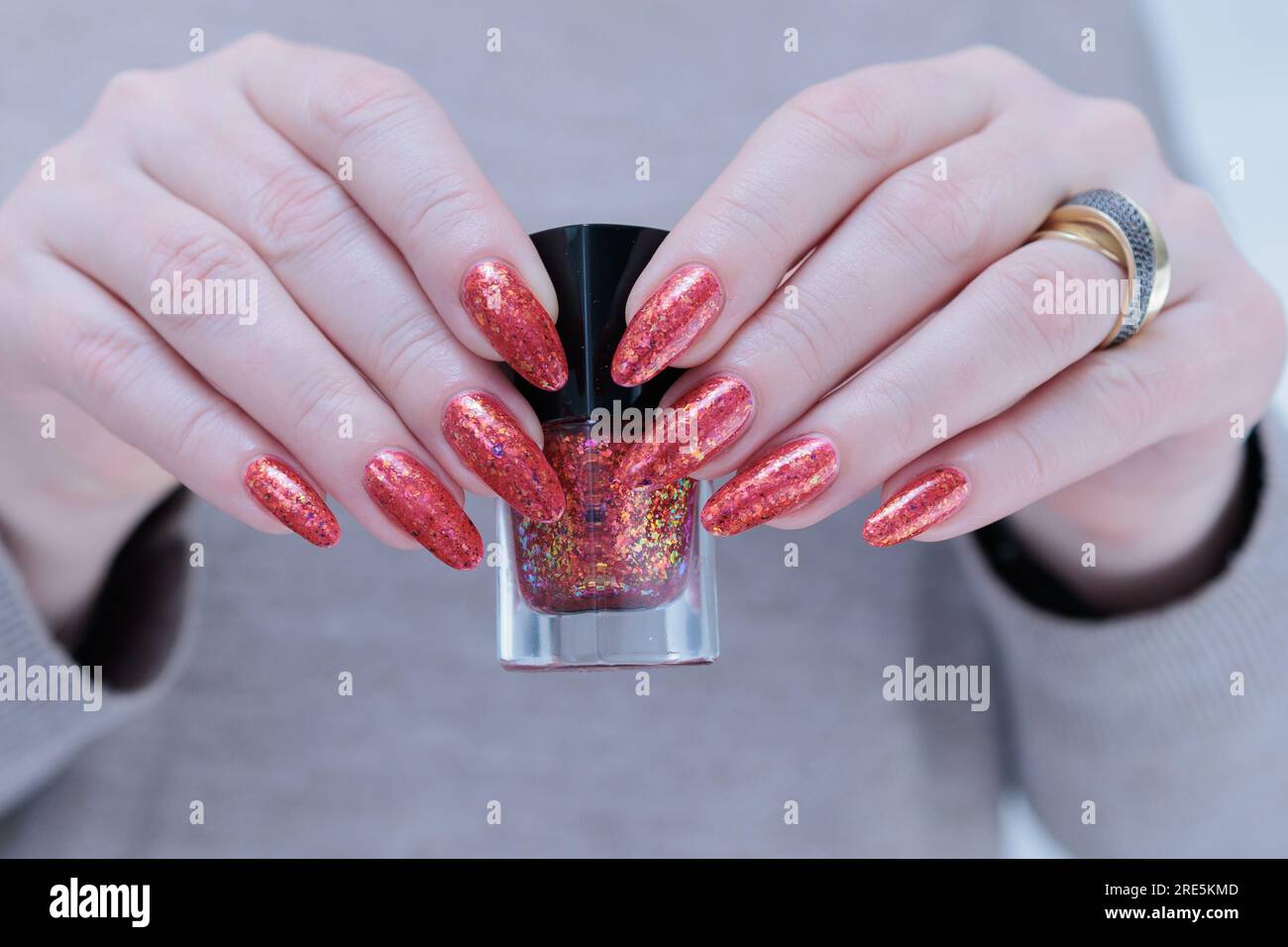 Female beautiful hand with long nails and a bright orange red nail ...