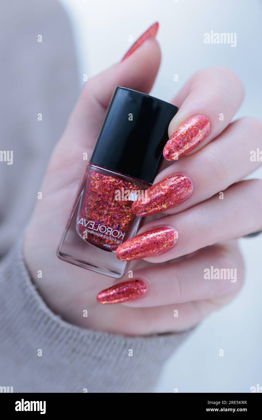 Female beautiful hand with long nails and a bright orange red nail ...