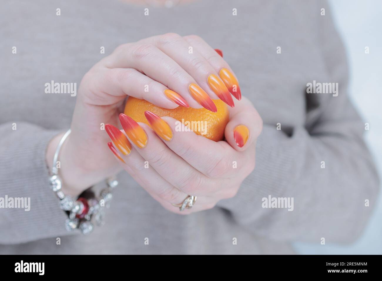 Woman's hands are holding a orange fruit Stock Photo - Alamy
