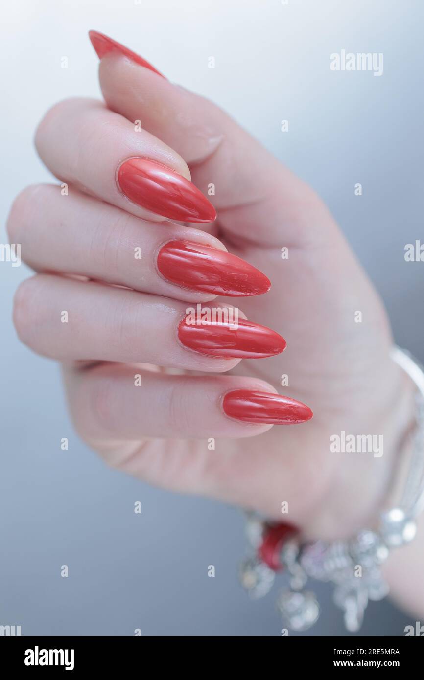 Female hand with long nails and a bright red manicure Stock Photo - Alamy