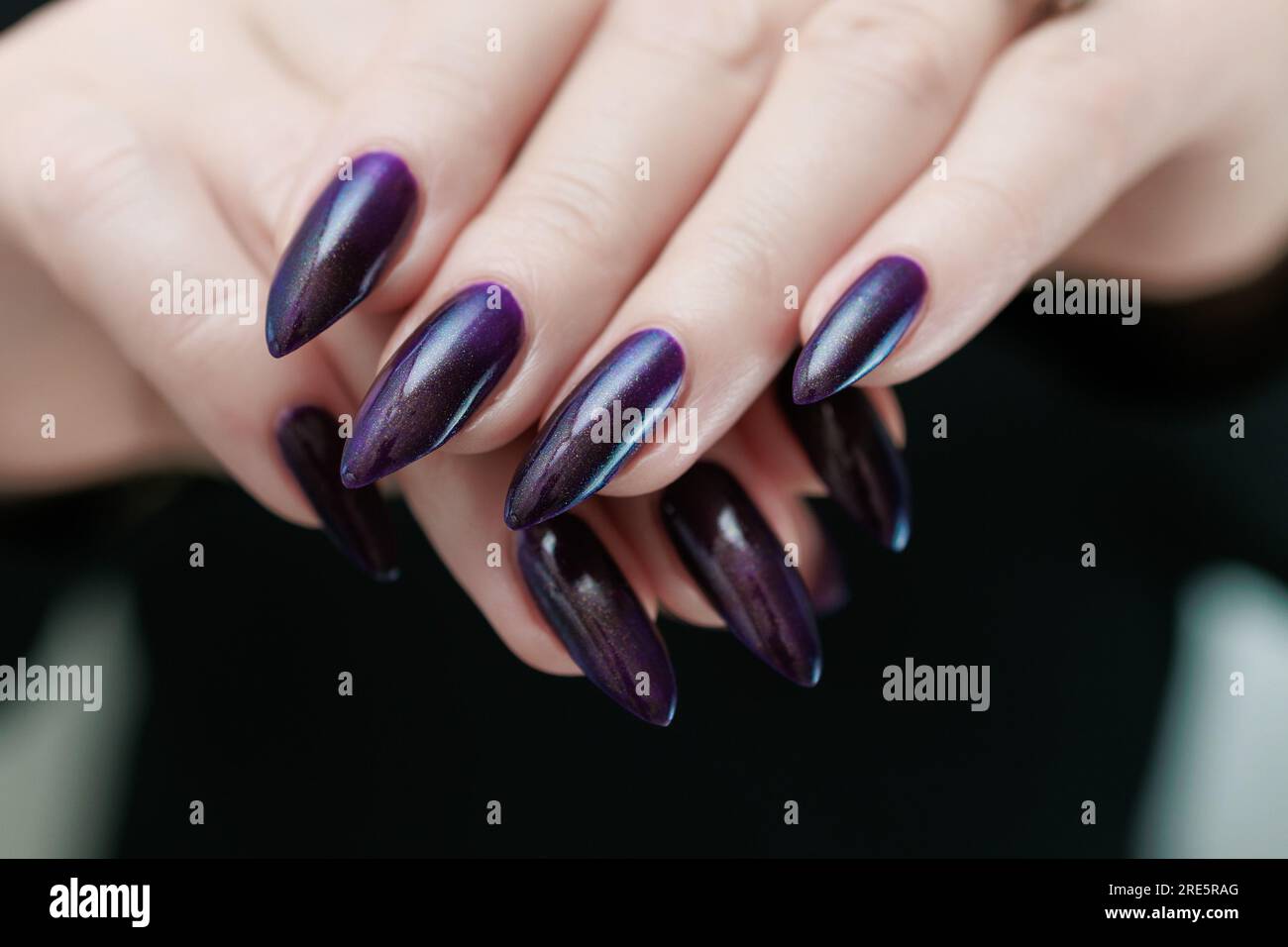 Female hands with long nails and black purple manicure Stock Photo - Alamy