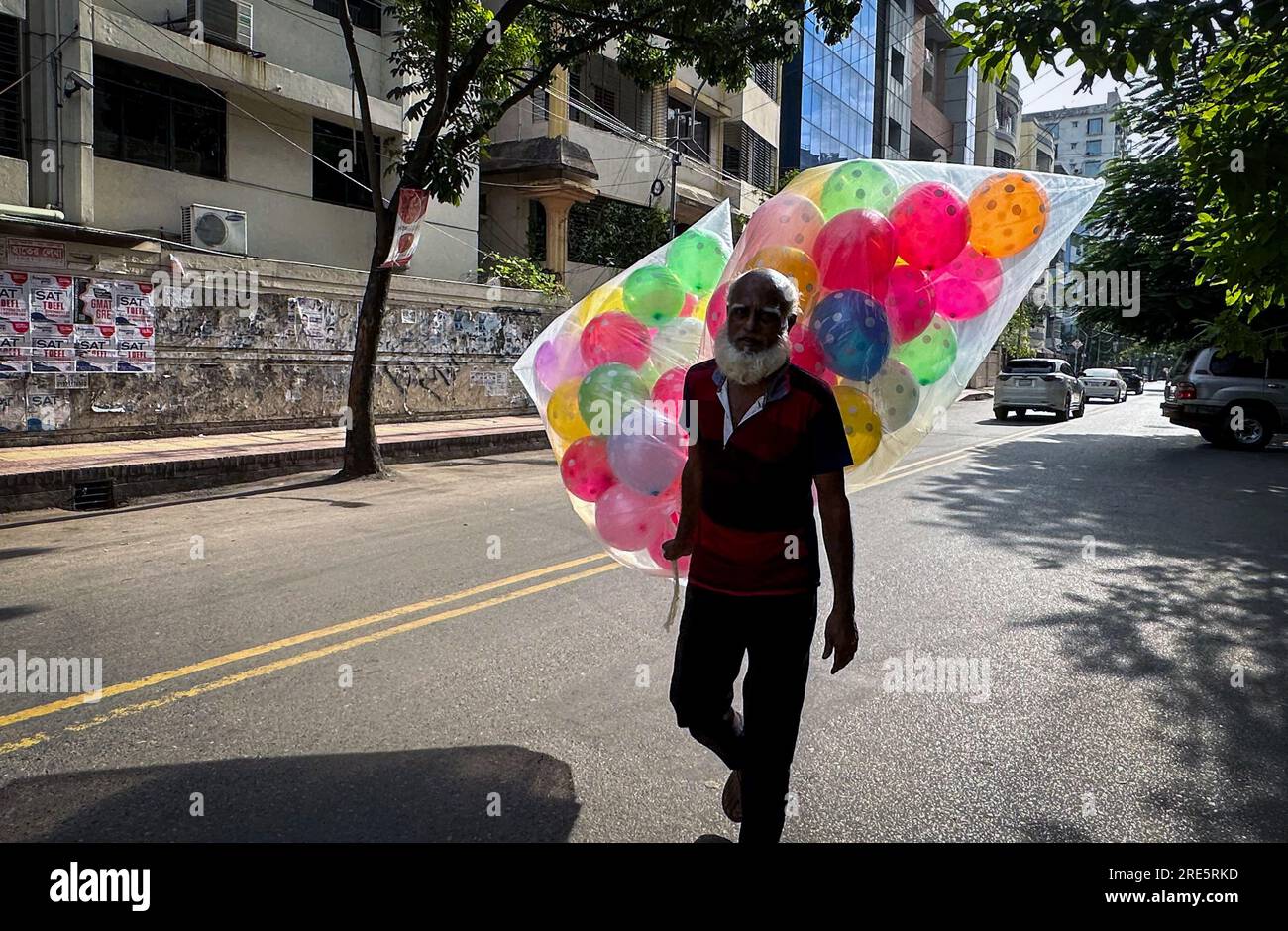Dhaka, Bangladesh. 25th July, 2023. A man carries bundle of balloons ...