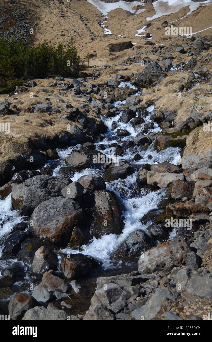 Snow melt waterfall down the side of a mountain in rural Iceland Stock ...