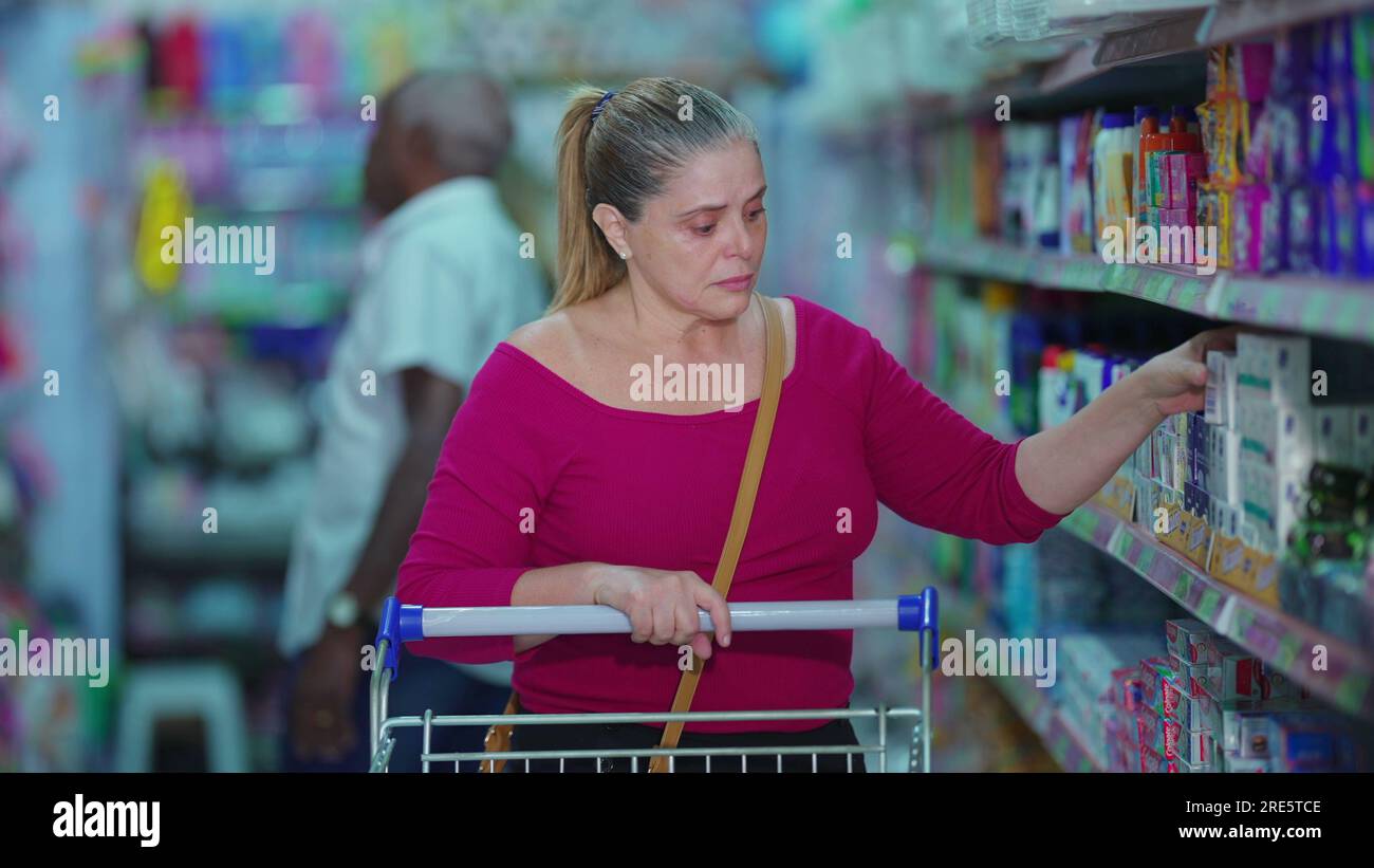Woman Browsing Items on Grocery Store Shelf in Aisle Stock Photo - Alamy