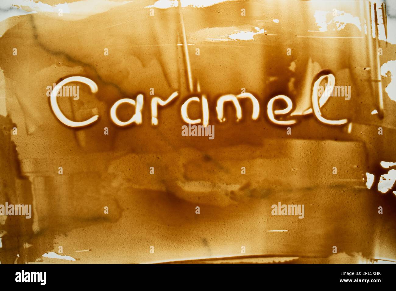 Salted Caramel sauce smeared on the tabletop with the Caramel word ...