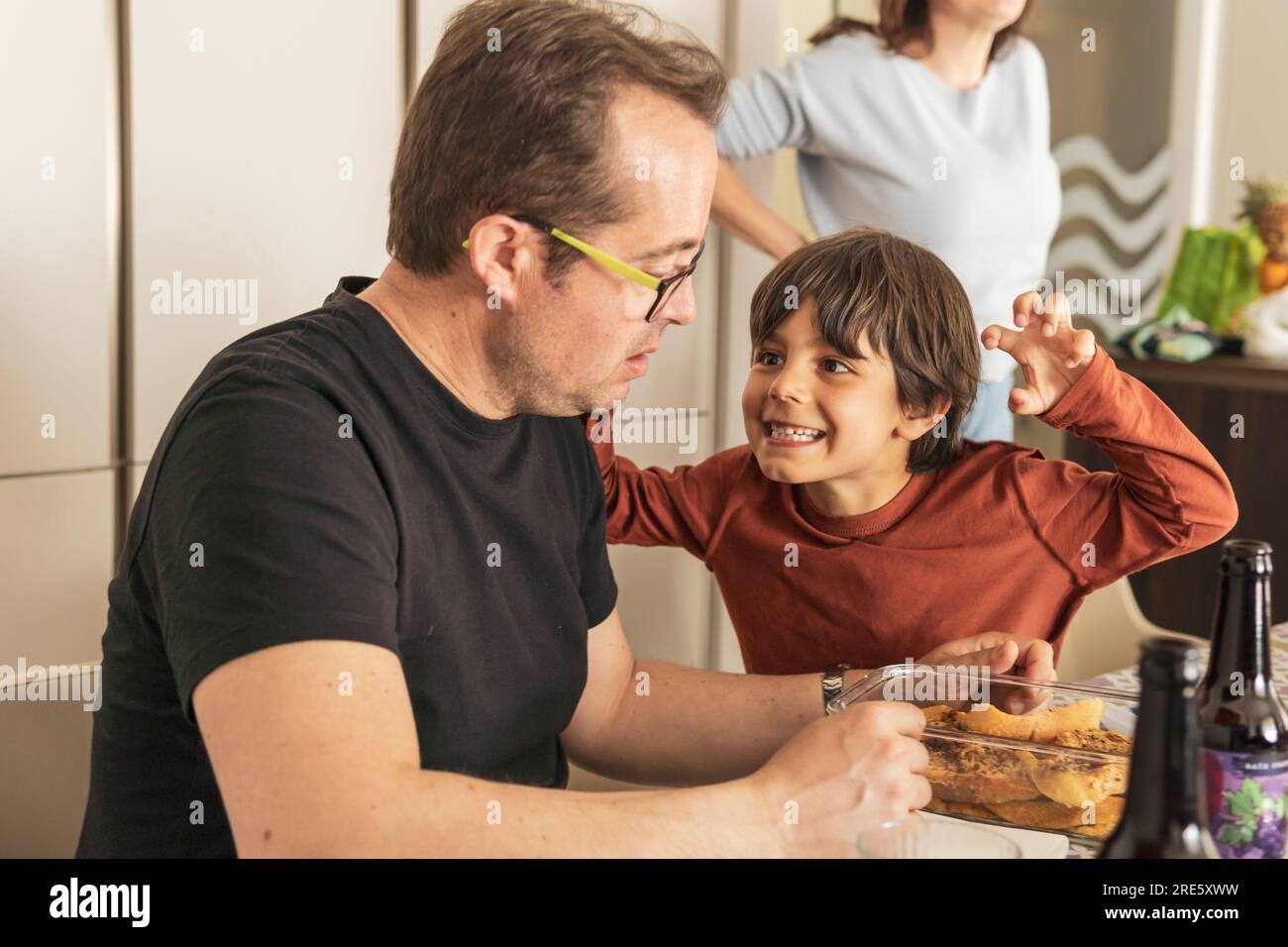 boy playing scare his family in the kitchen Stock Photo - Alamy