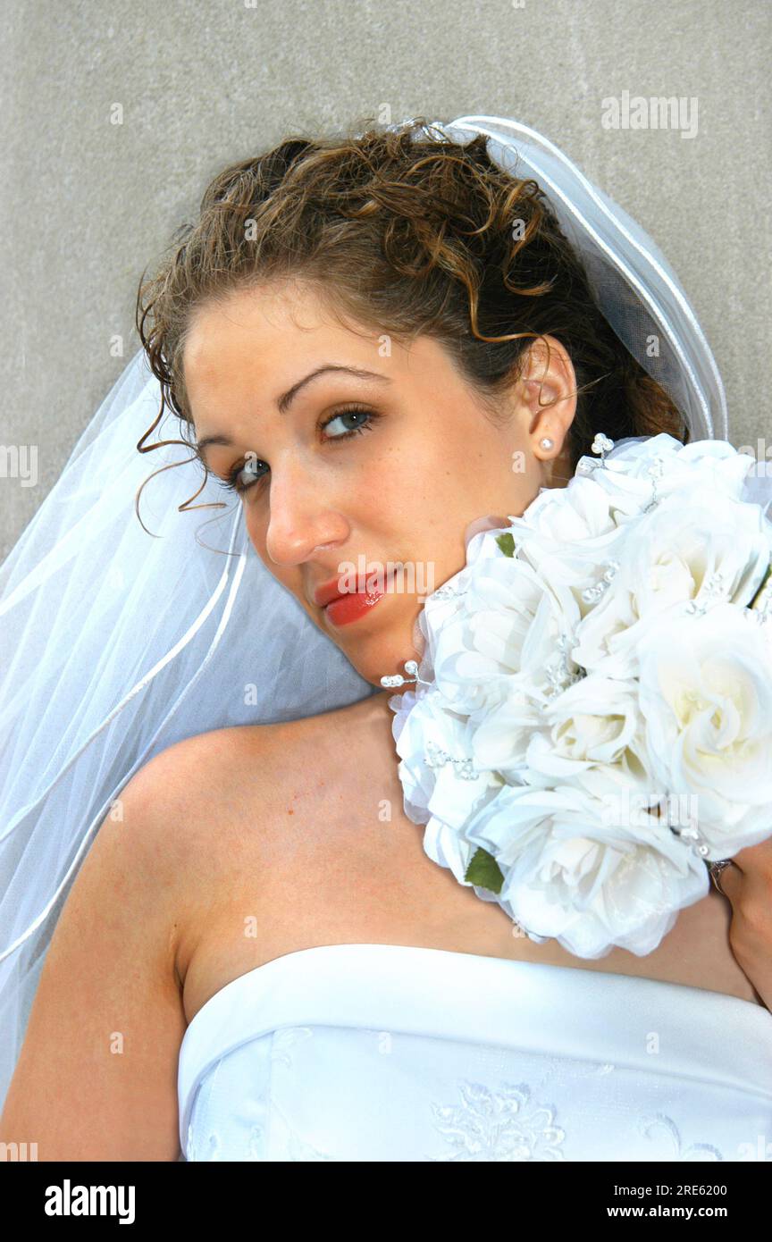 Beautiful Young Bride Holds Her Bouquet Close To Her Face She Is