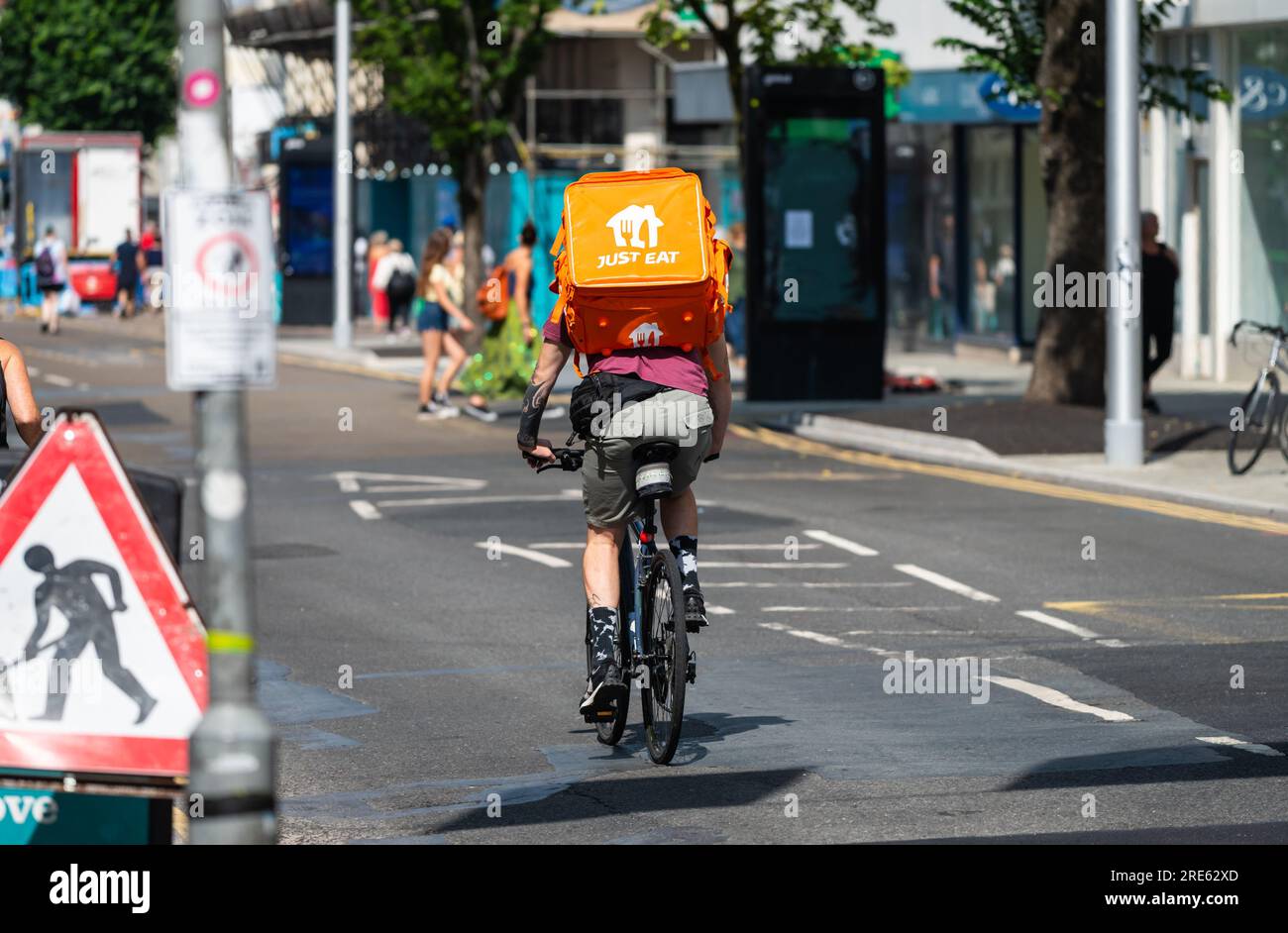 Cyclist riding a bicycle delivering food for Just Eat in Brighton ...