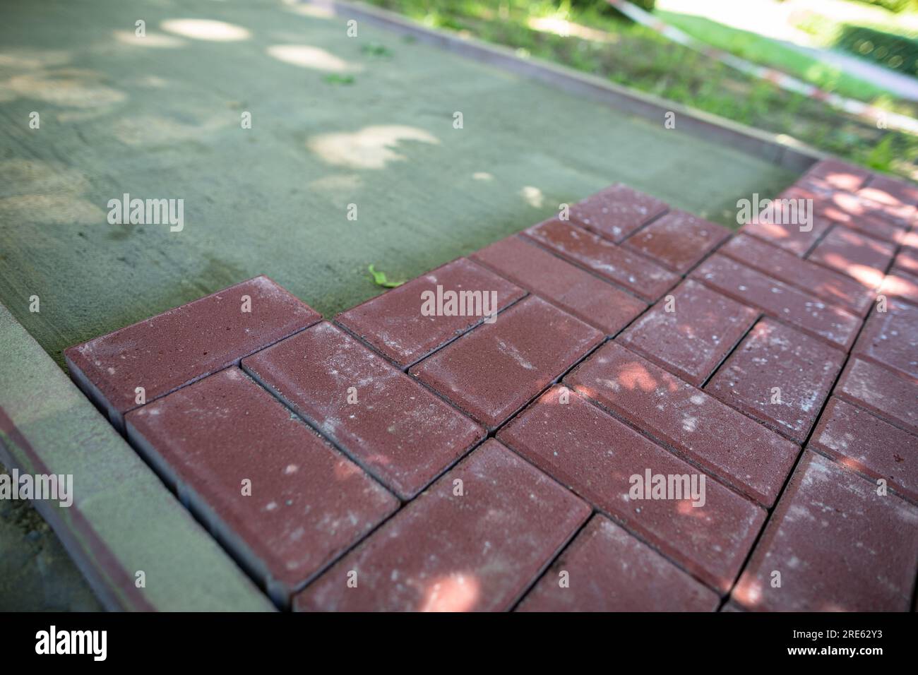 Unfinished pedestrian walkway made of rectangular red paving stones ...