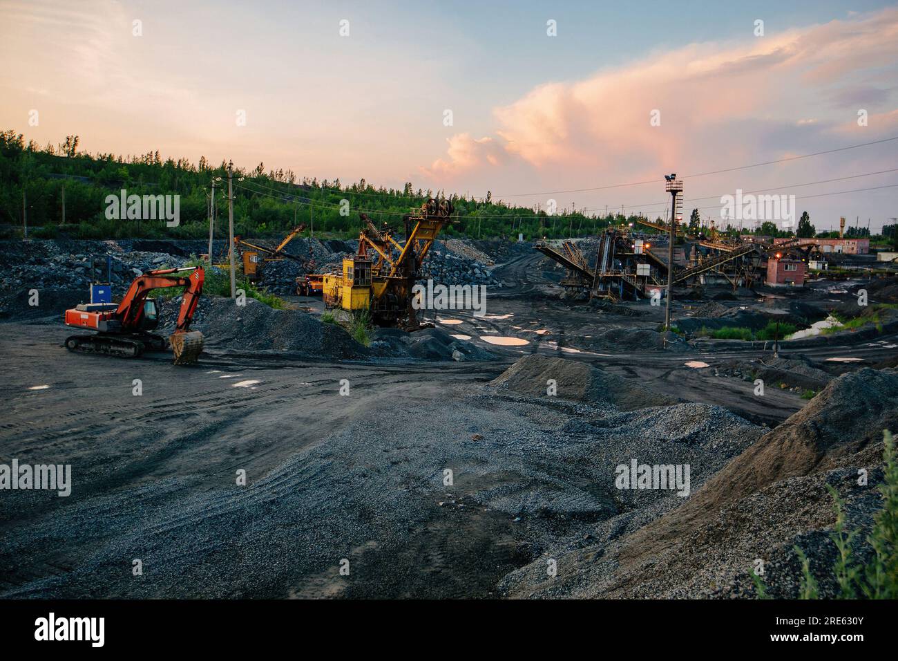 Excavators and dump trucks working on earthmoving at open pit mine in ...