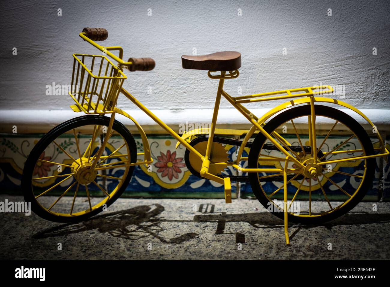 Vintage metal yellow bicycle toy with wooden elements on a shelf as a ...