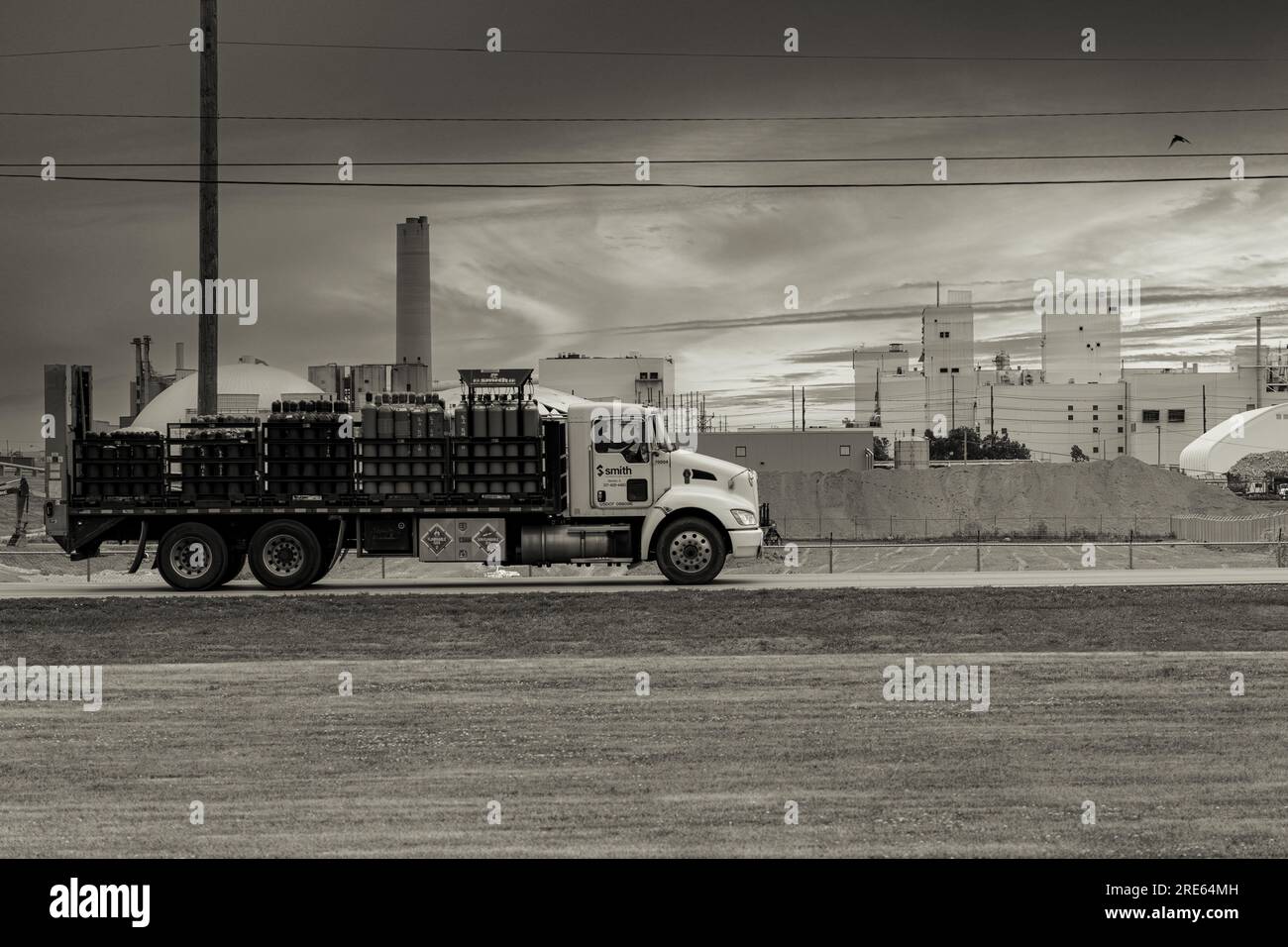 Industry truck carrying CO2 tanks with industrial buildings in ...
