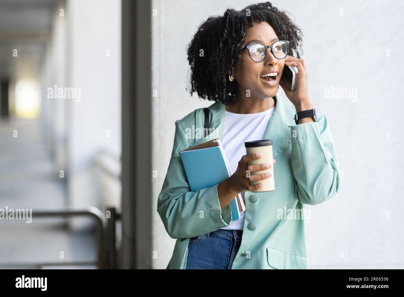 Pretty young black woman employee have phone call Stock Photo - Alamy