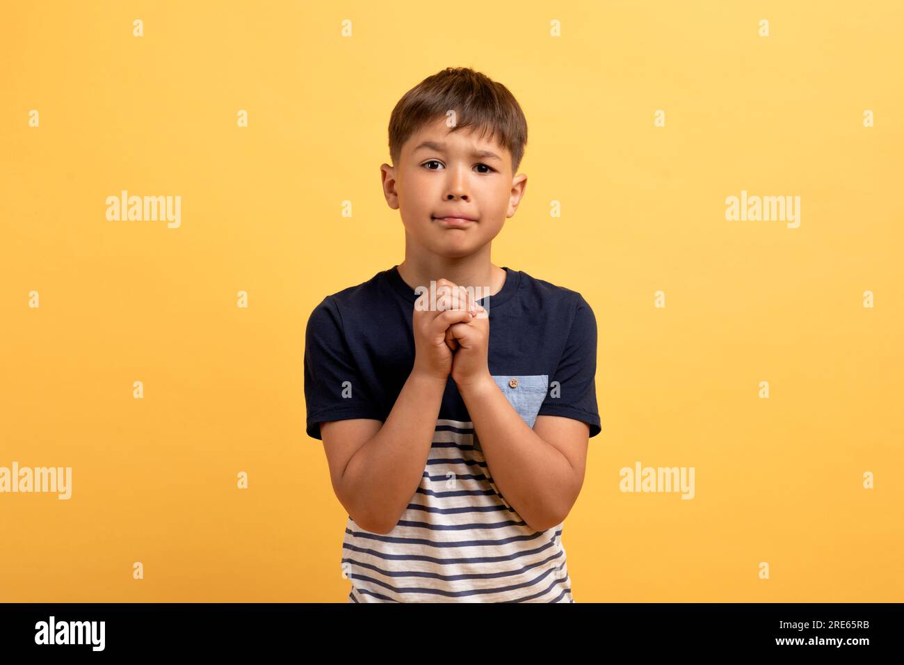 Funny boy begging for his request on yellow background Stock Photo - Alamy