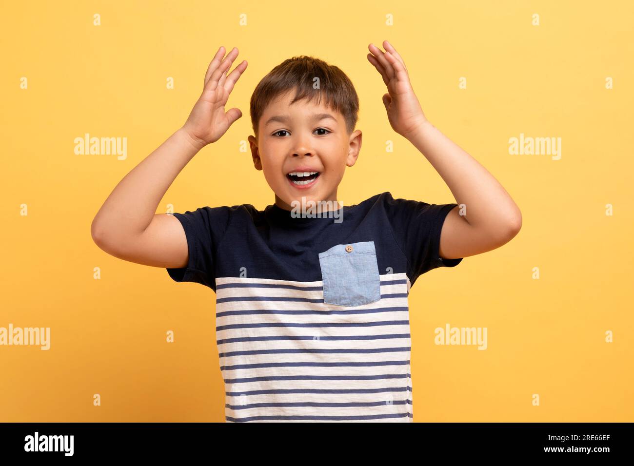 Emotional happy boy raising hands up, expressing happiness Stock Photo ...