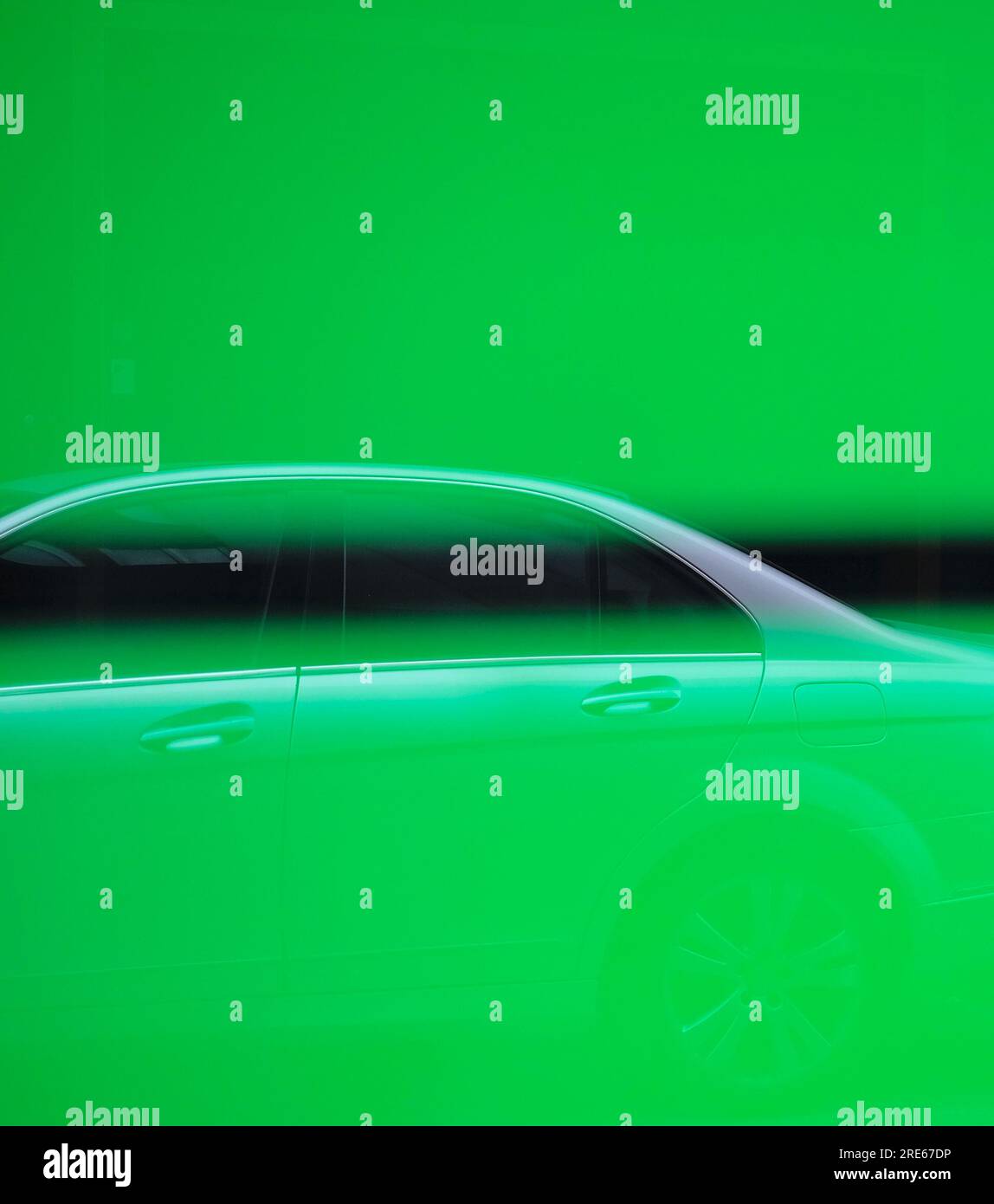 Reflection of a modern silver car in a glass surface with neon green ...