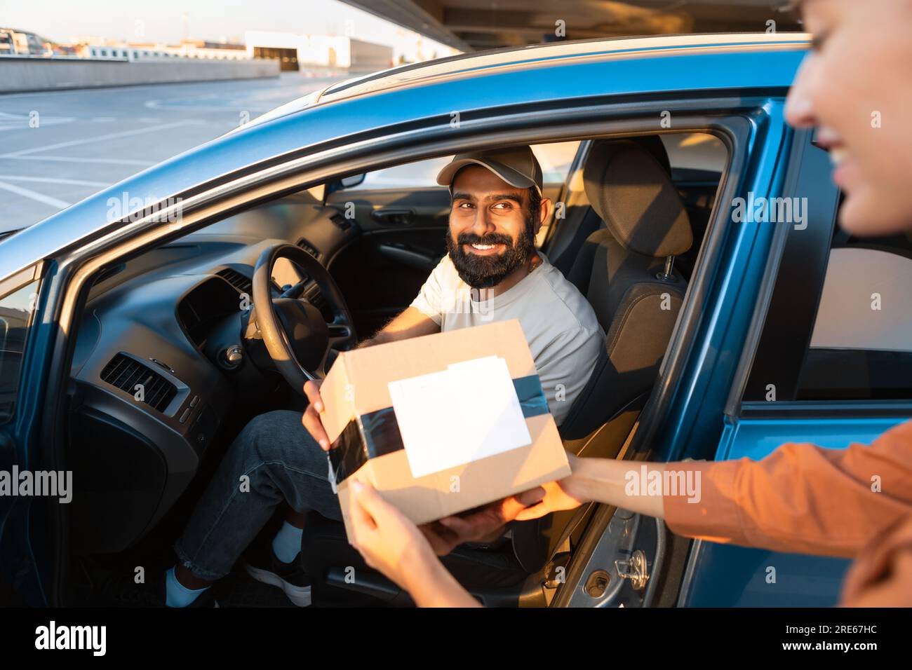 Arabic Courier Guy Giving Parcel Box To Customer From Car Stock Photo ...