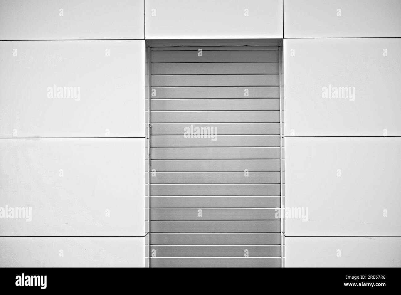 Silver door closed with aluminum shutters in a gray metalic wall, a ...
