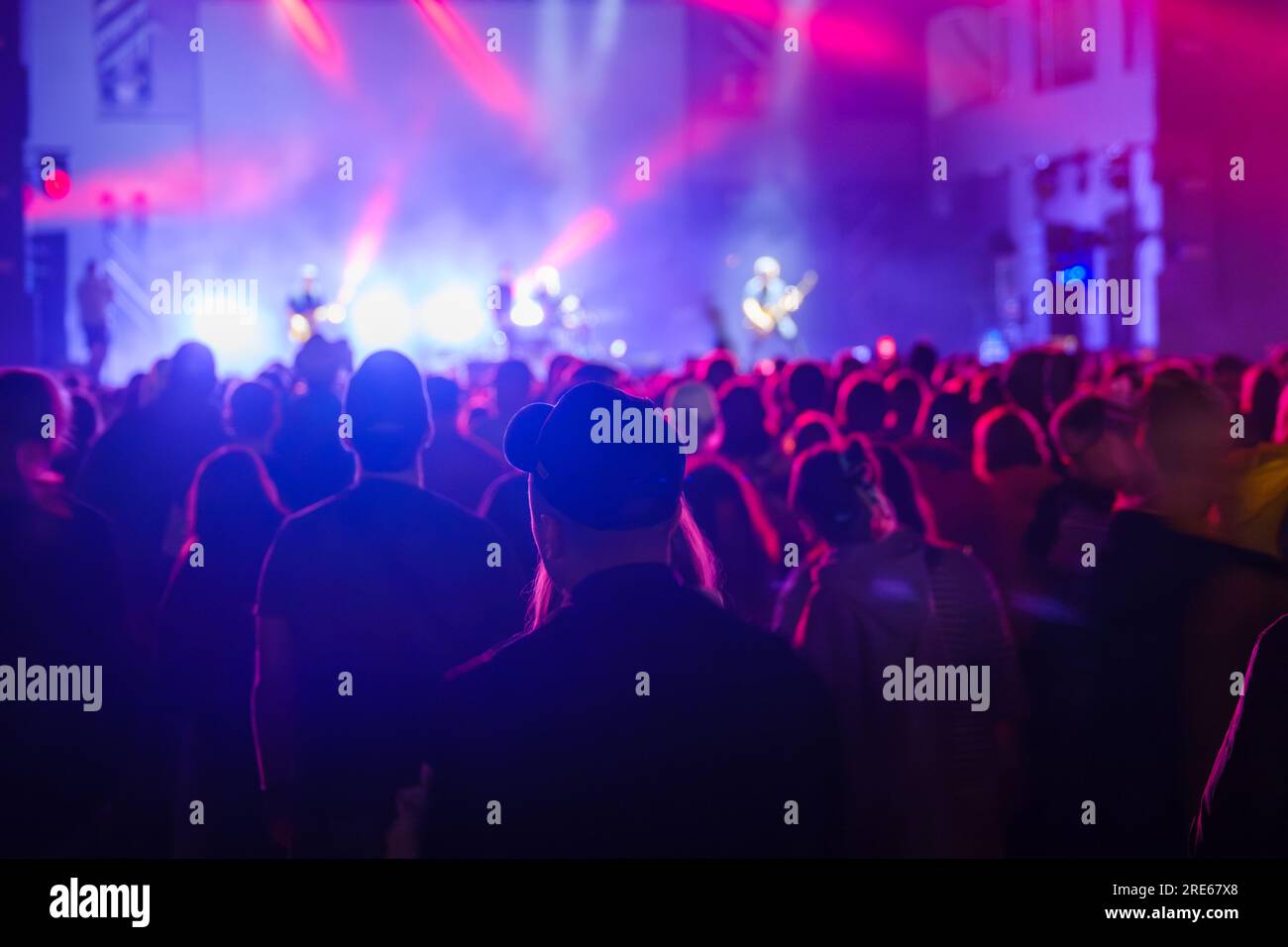 Back view of anonymous spectators looking away while standing near ...