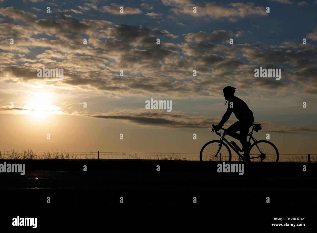 A cyclist rides on a county highway while riding in The Des Moines ...