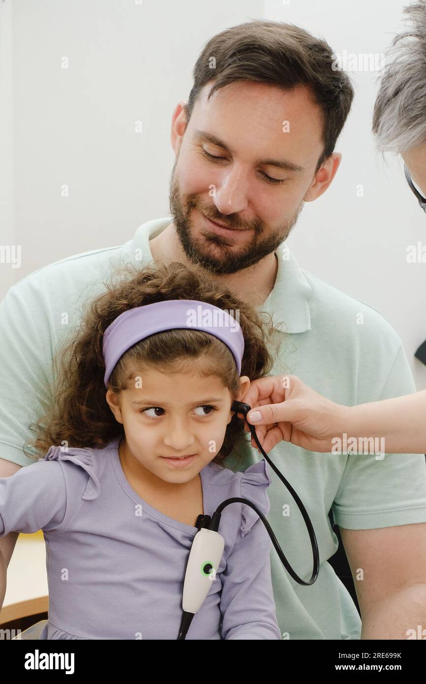 Child hearing test. Doctor audiologist examining kids ear and assess ... Child hearing test. Doctor audiologist examining kids ear and assess ...