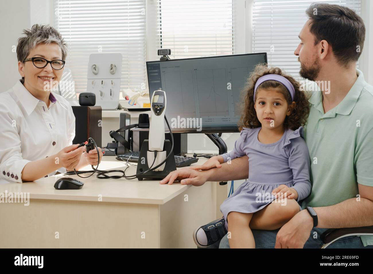 Child hearing test. Doctor audiologist consulting father of girl ear ...