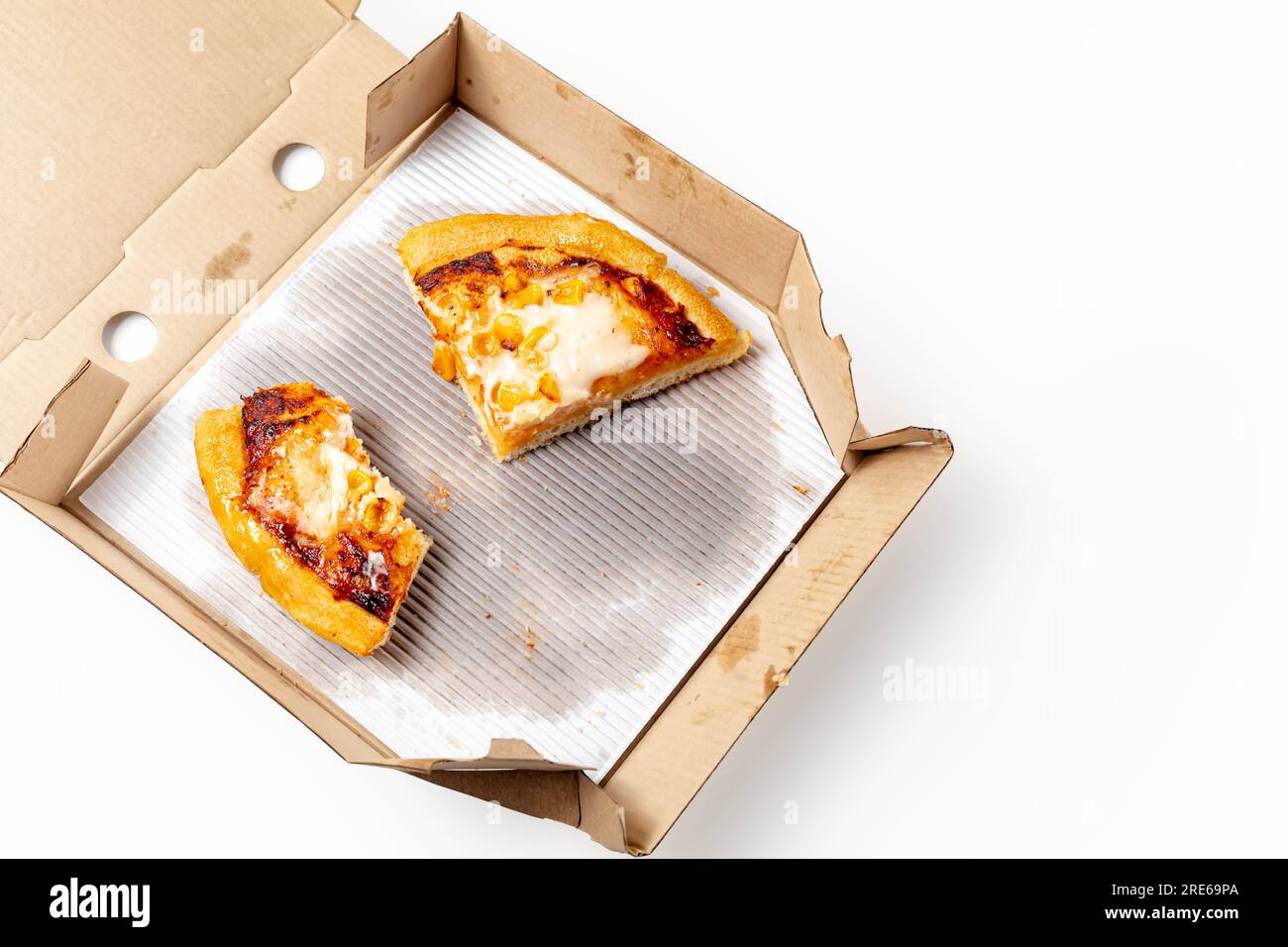 Leftover corn pizza in an open cardboard pizza box. Top view Stock ...