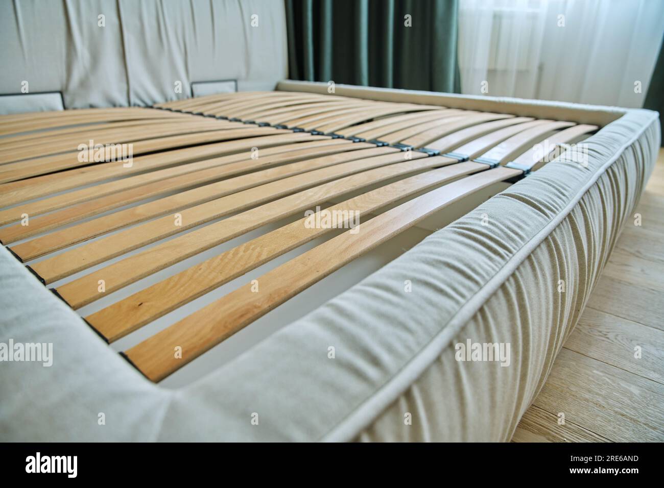 Large bed with wooden slats without mattress in bedroom interior Stock ...