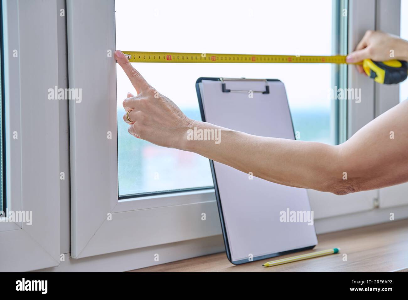 Woman measuring window with tape measure, tailoring service Stock Photo ...