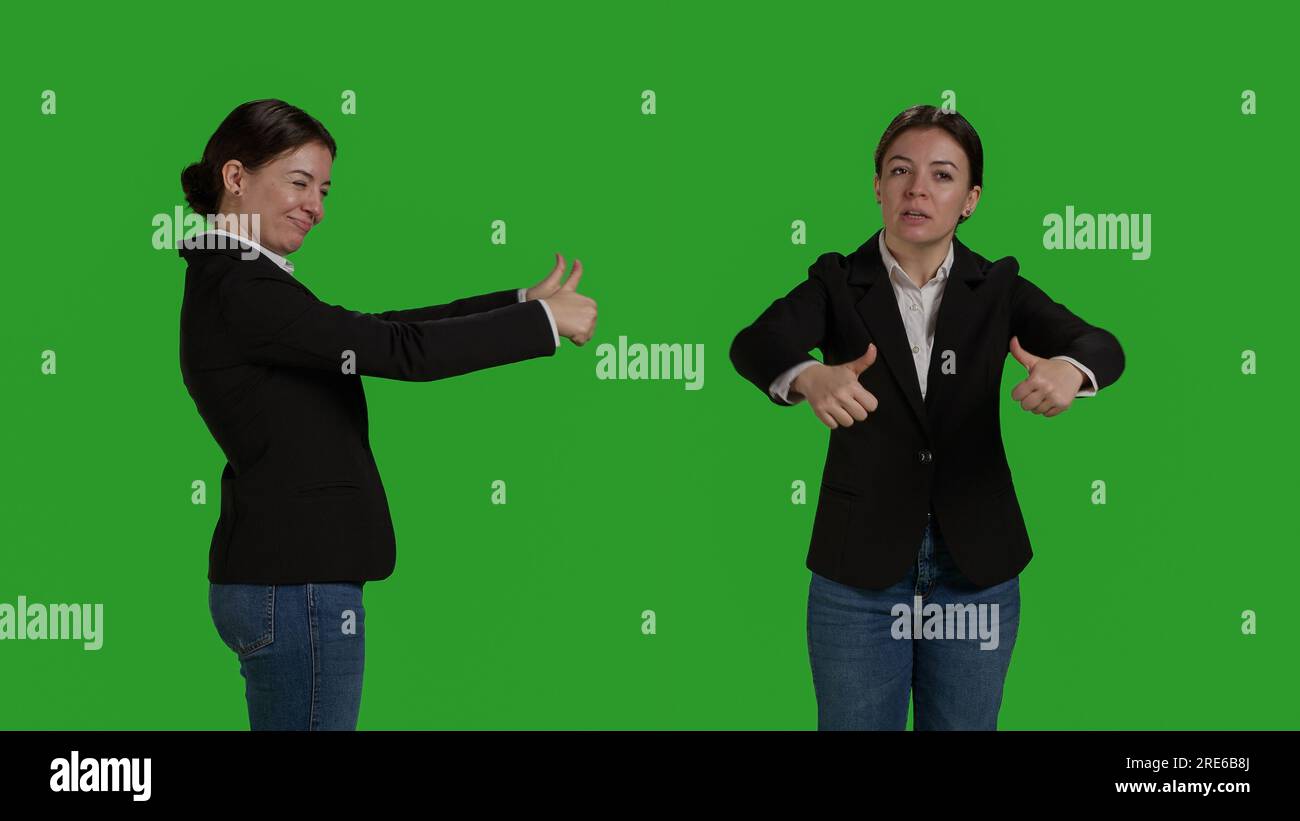 Close up of optimistic worker giving thumbs up over greenscreen ...