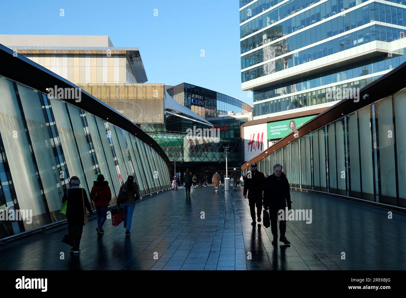 People walking across a footbridge over railway lines towards Stratford ...