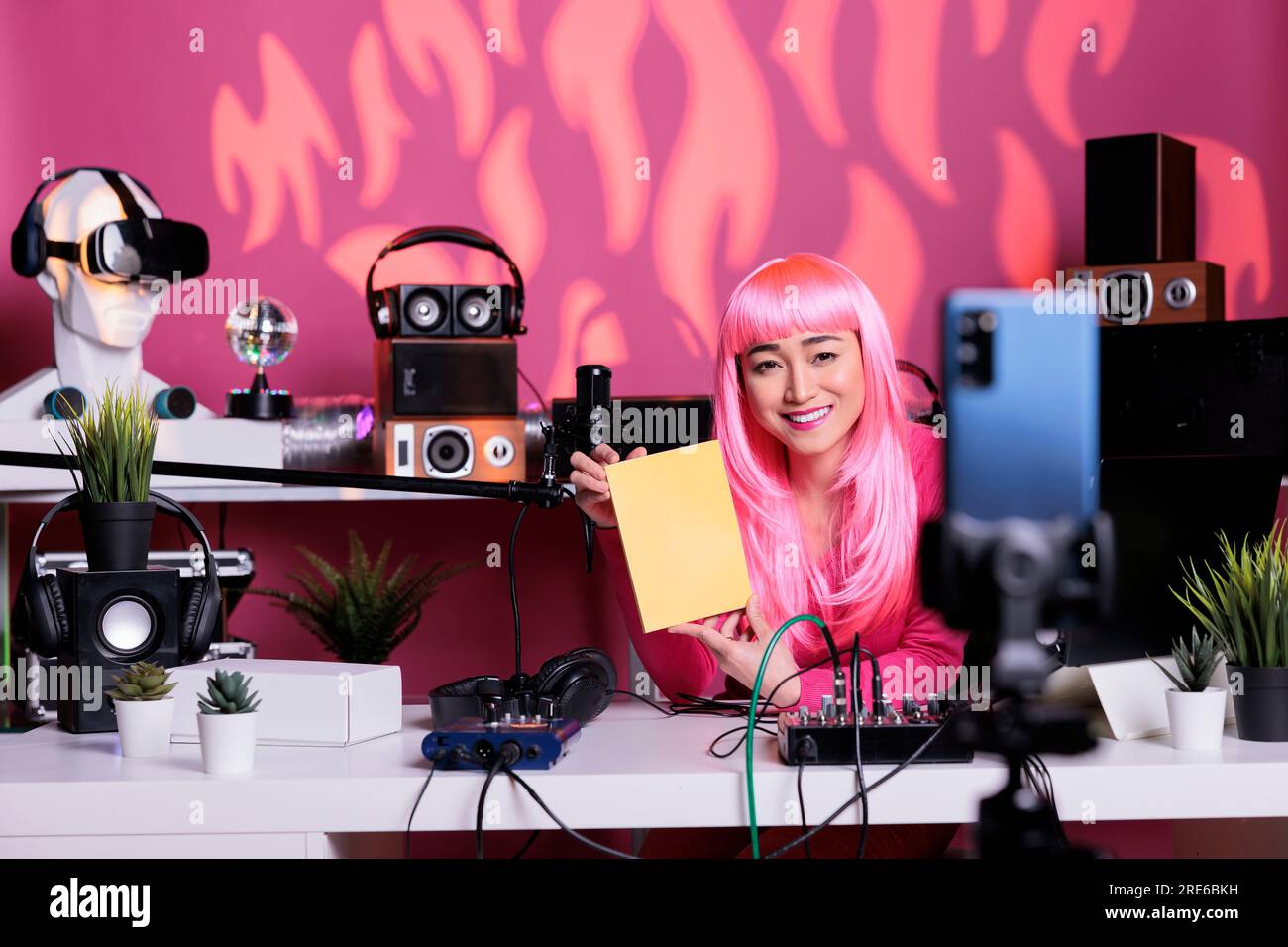 Smiling asian content creator holding notebook presenting school ...