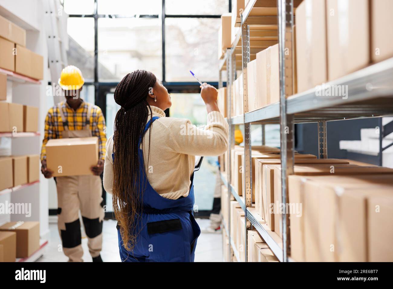 Industrial warehouse employee managing freight inventory, standing near ...