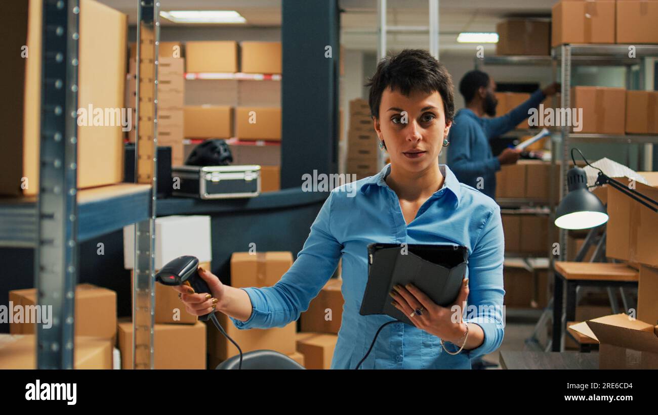 Young entrepreneur using scanner and tablet to do inventory, scanning ...