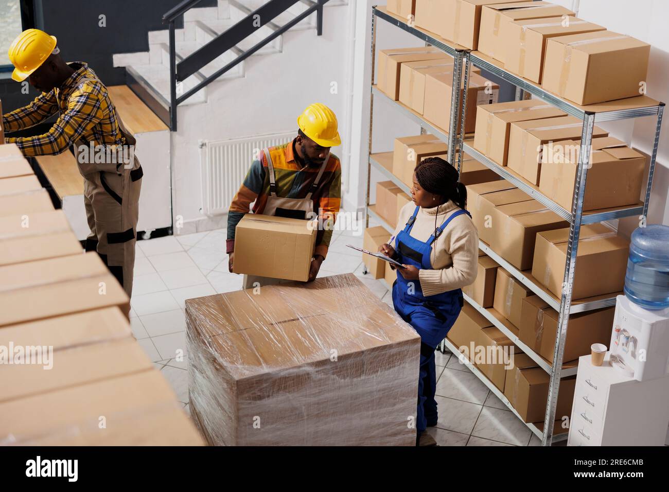 African american warehouse loader giving cardboard box to supervisor in ...