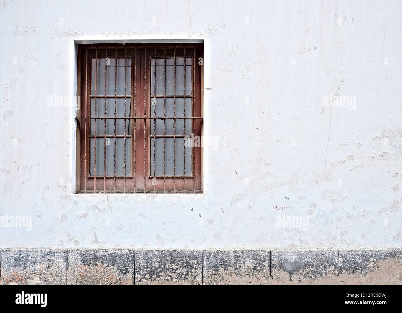 Bleak barred window in a grungy white wall, concept of old abandoned ...