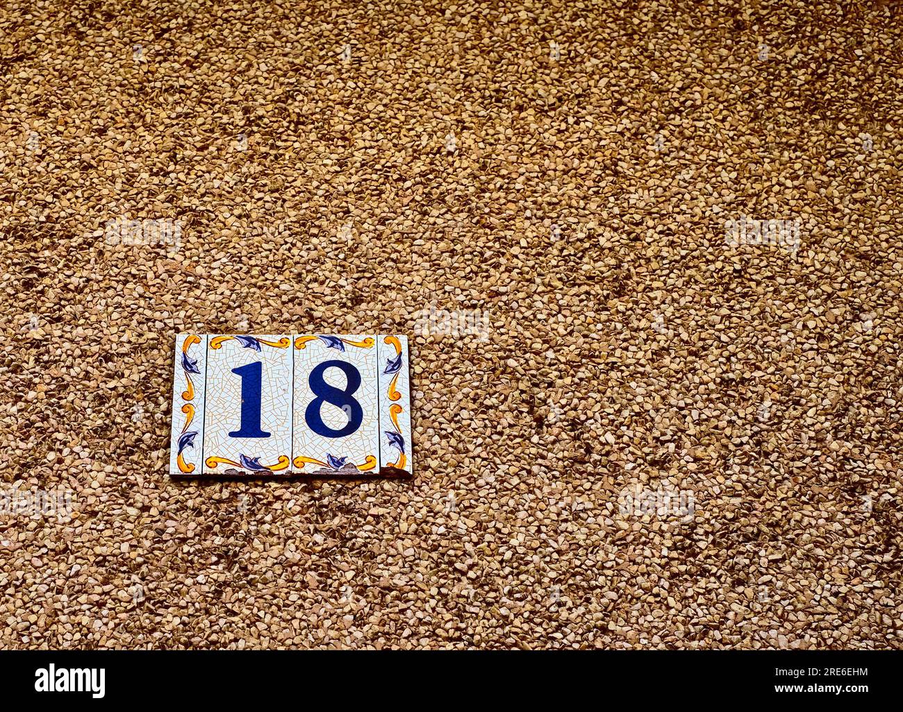 Number 18, eighteen, decorative tiles offset on a brown wall background ...