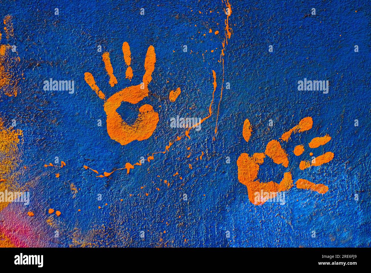 Two orange handprints on a blue background Stock Photo - Alamy